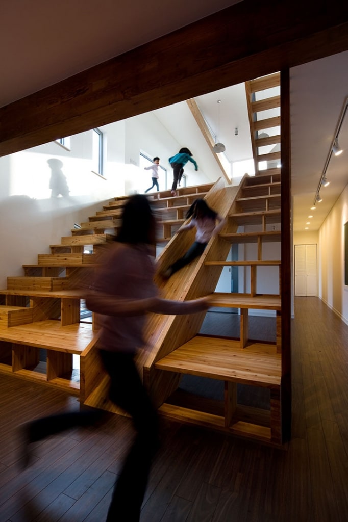 Playful Wooden Slide Formed Within a Bookshelf